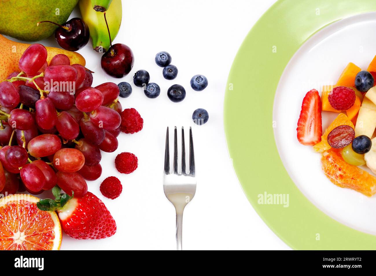 Fresh whole fruit, next to it plate with cut fruit Stock Photo - Alamy
