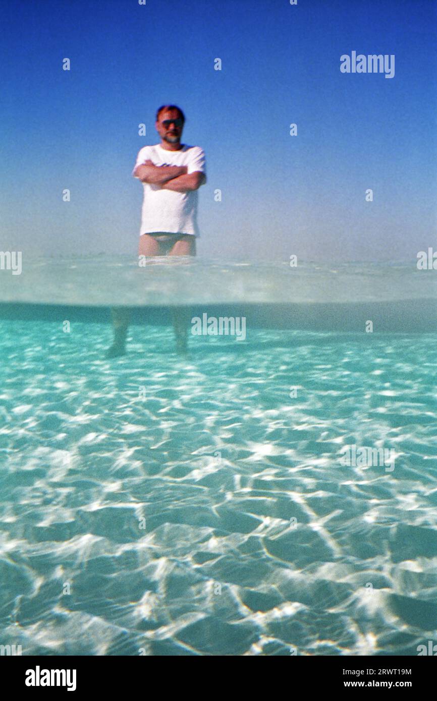 Holidaymakers in shallow water on the beach, half-and-half shot, Cayo ...