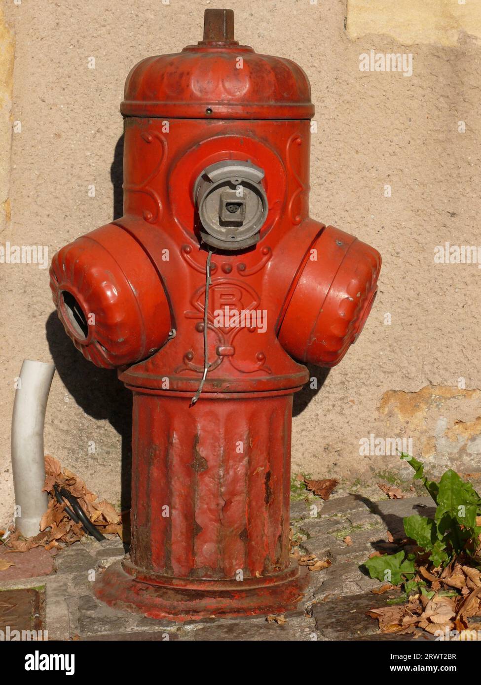 Red surface hydrant, in the background a house wall Stock Photo - Alamy