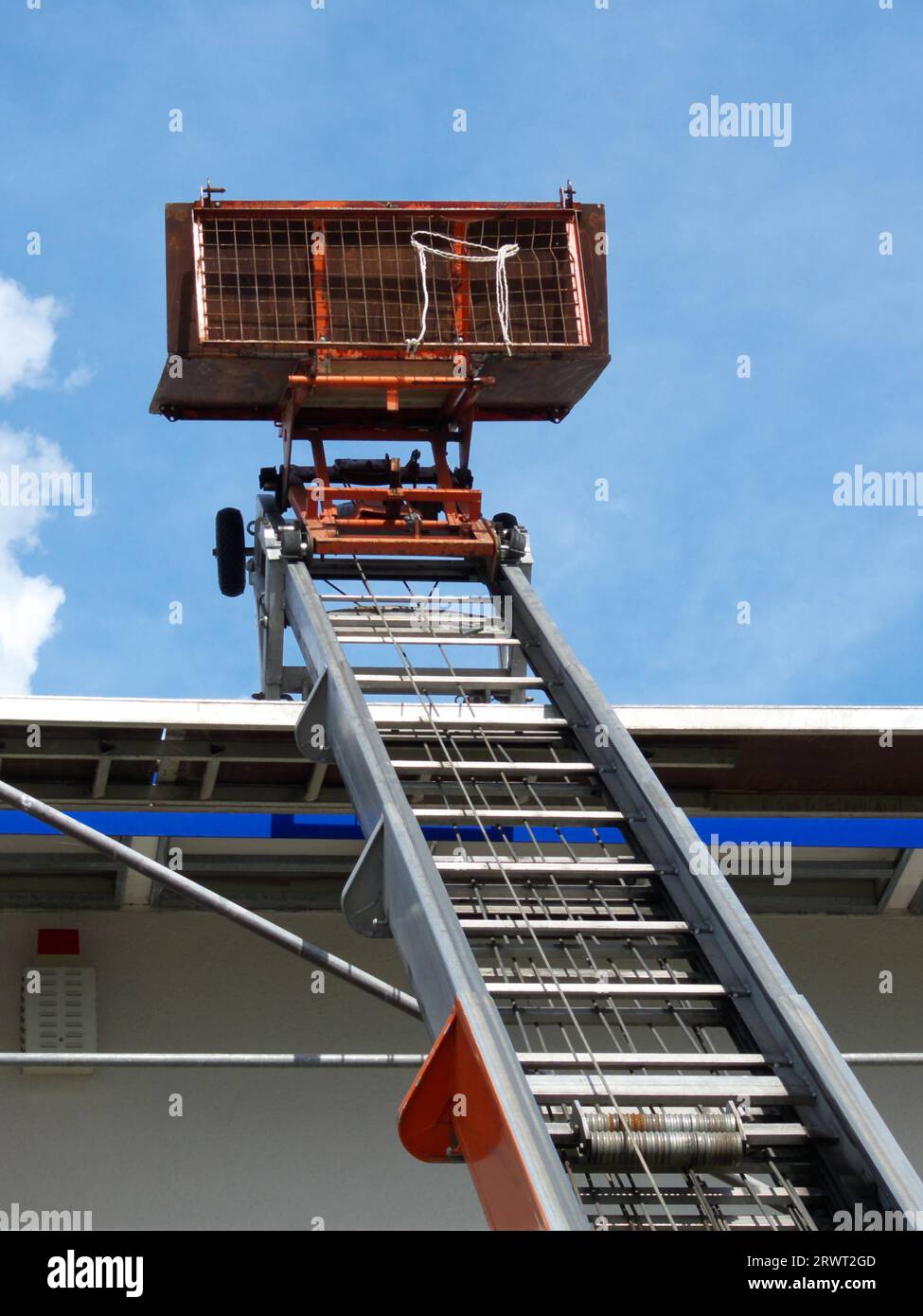 Inclined lift, extended, in front of house, in the background blue sky ...