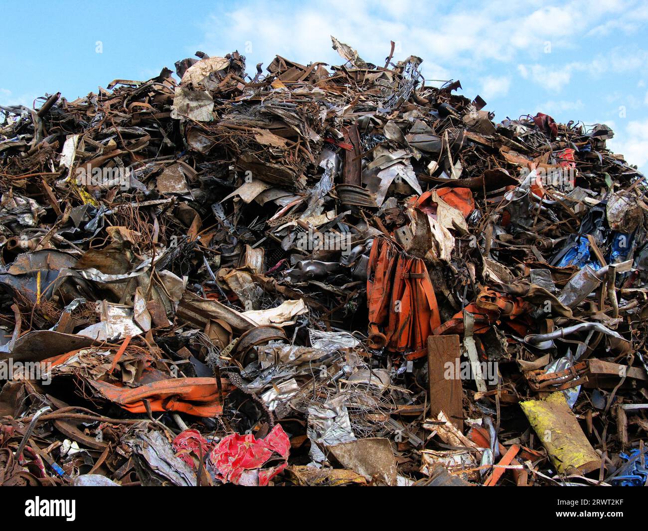 Scrap metal mountain, in the background light blue sky with white ...