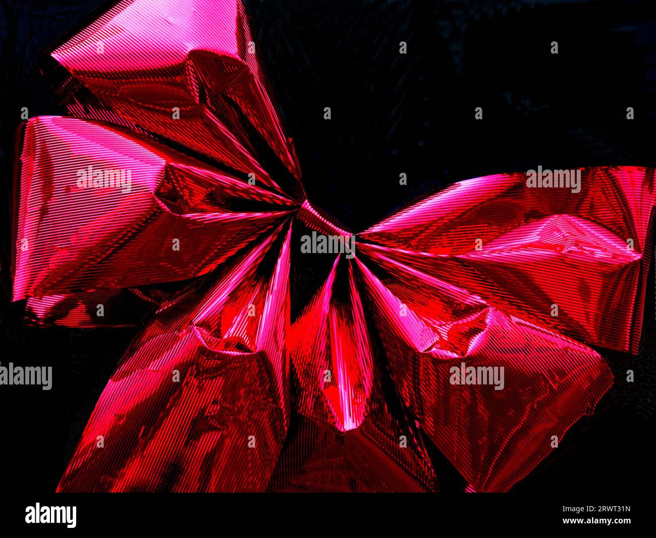 Red shiny bow against a black background Stock Photo - Alamy