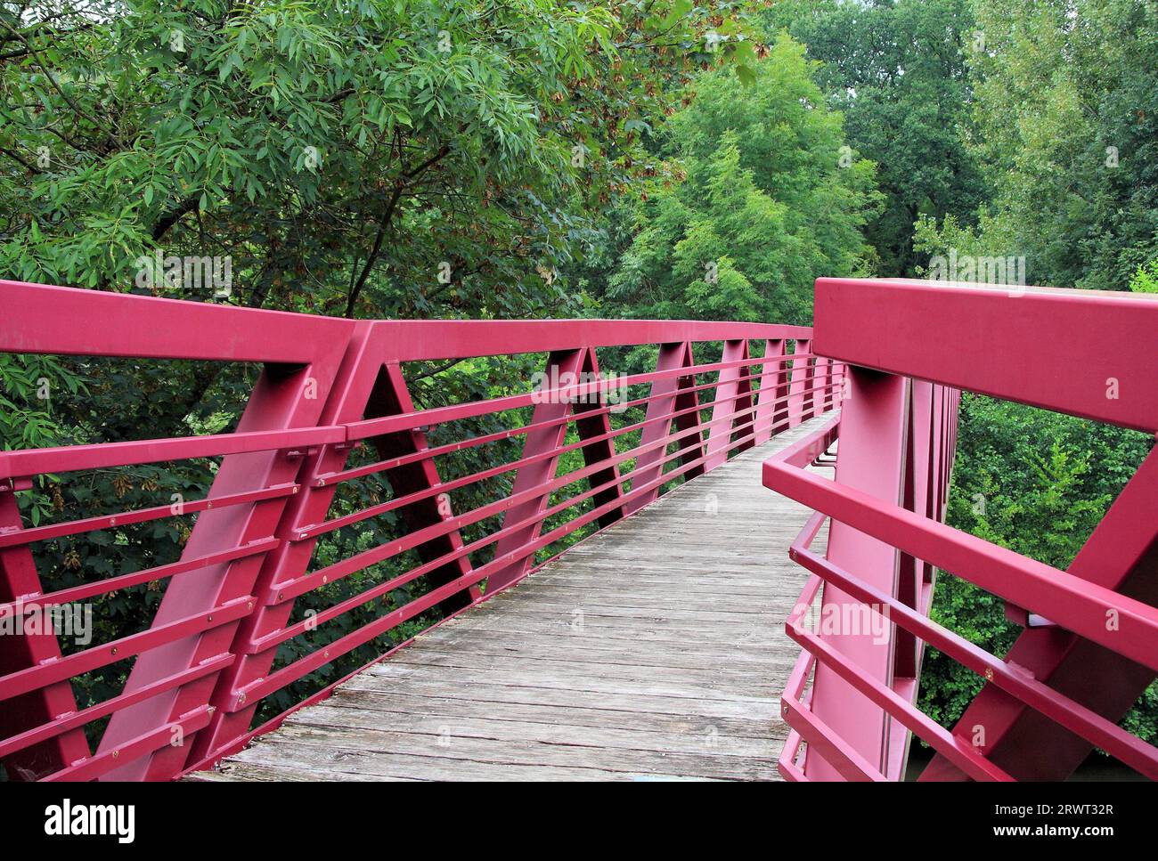 Red-painted iron bridge with wooden footbridge leading directly into ...