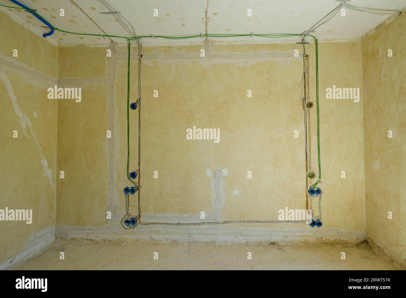 Power and network cables on a wall, empty sockets for electrical ...