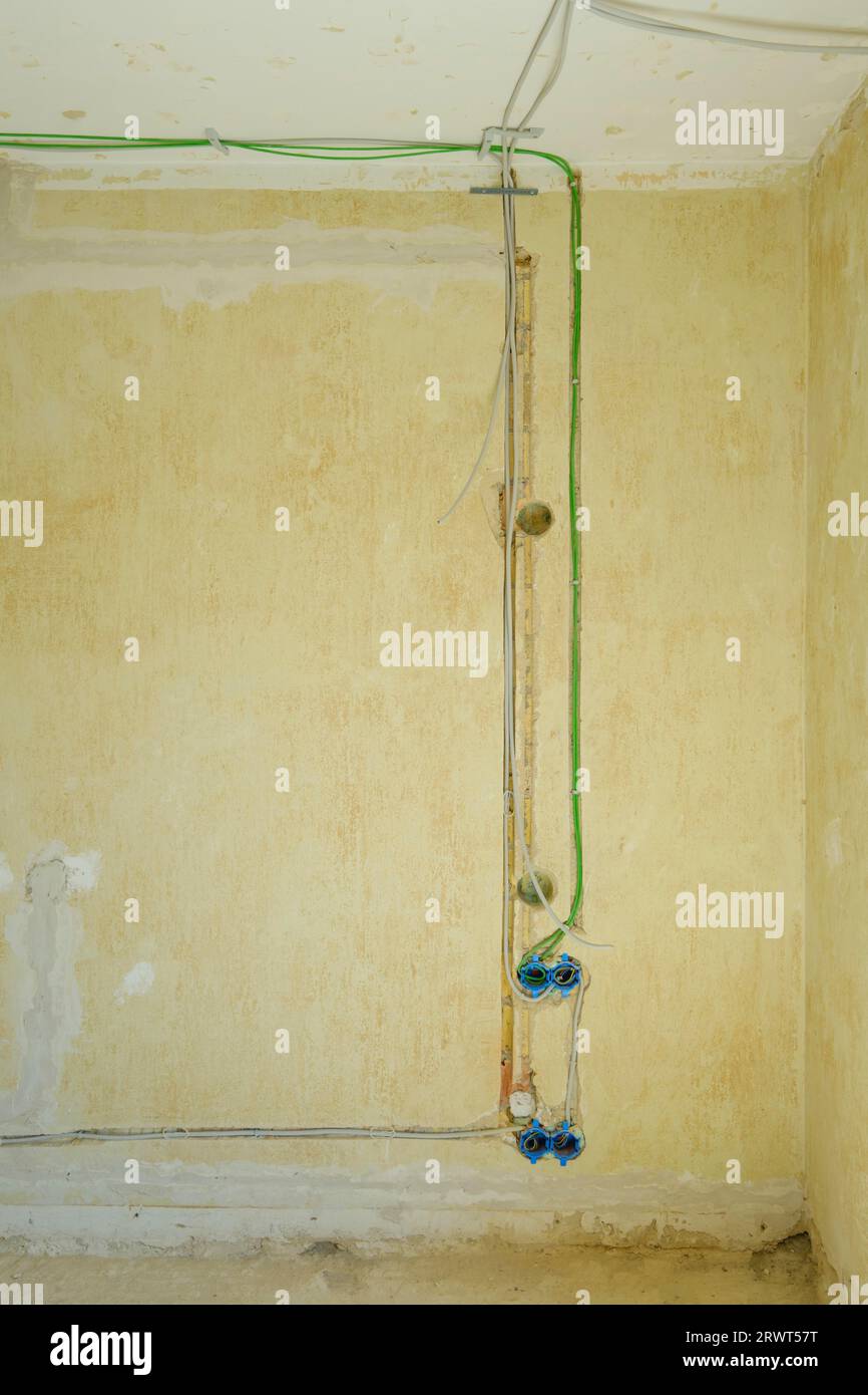 Power and network cables on a wall, empty sockets for electrical ...