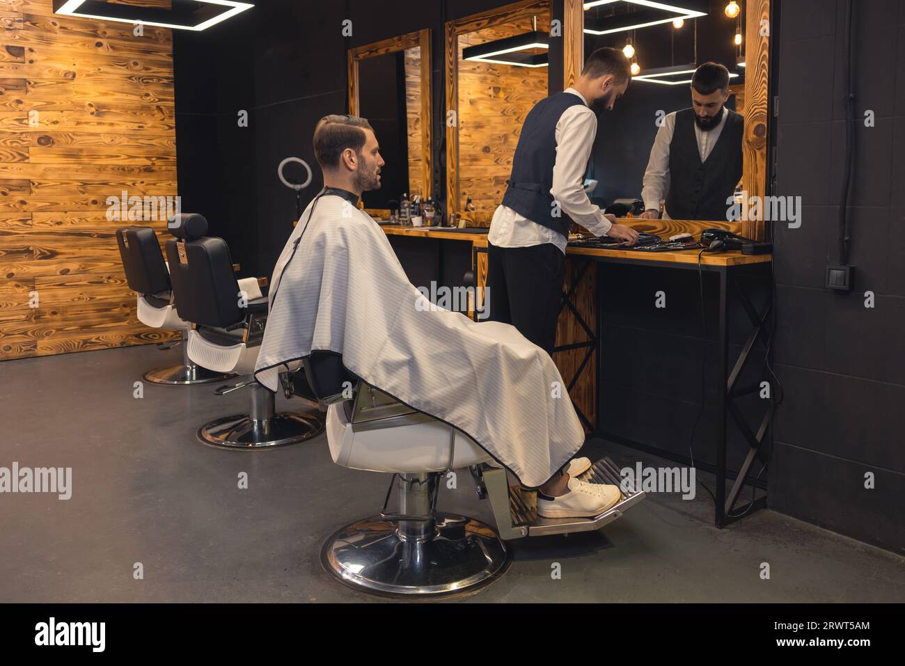 Man getting new trendy haircut or hairstyle with professional male ...