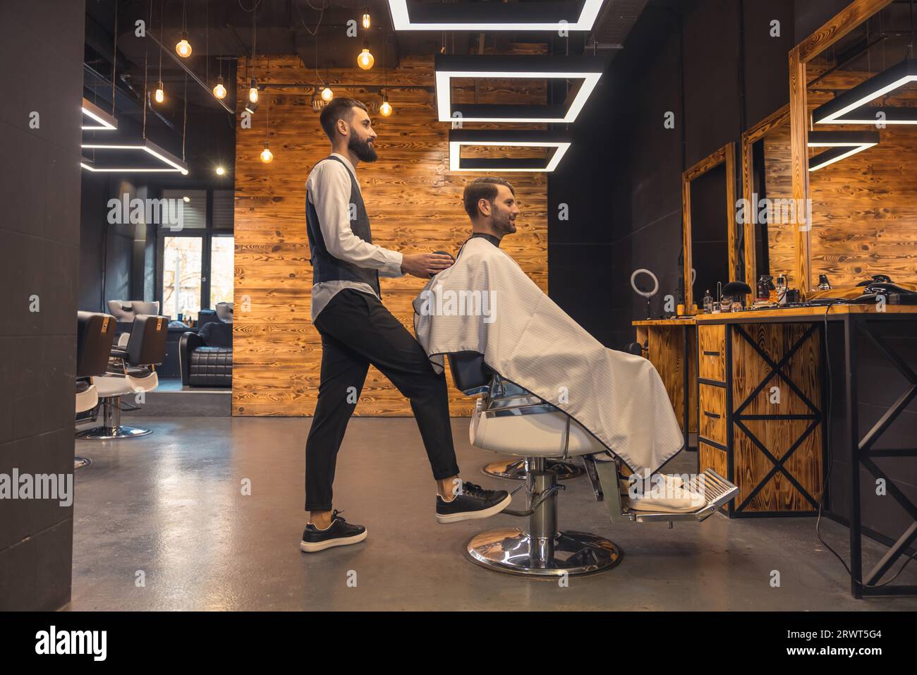 Man getting new trendy haircut or hairstyle with professional male ...
