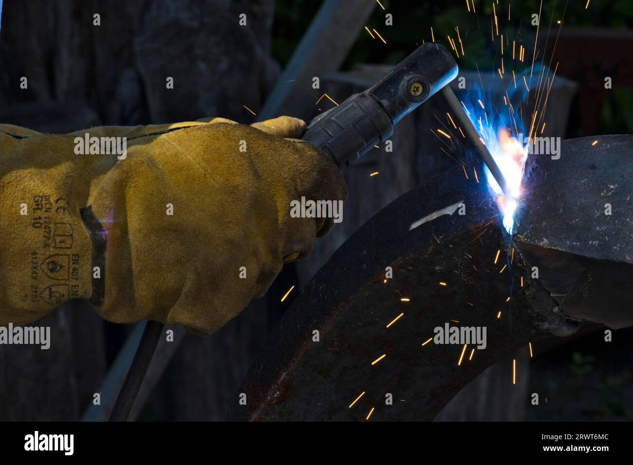The welding of a piece of metal by means of an electric welder and a ...