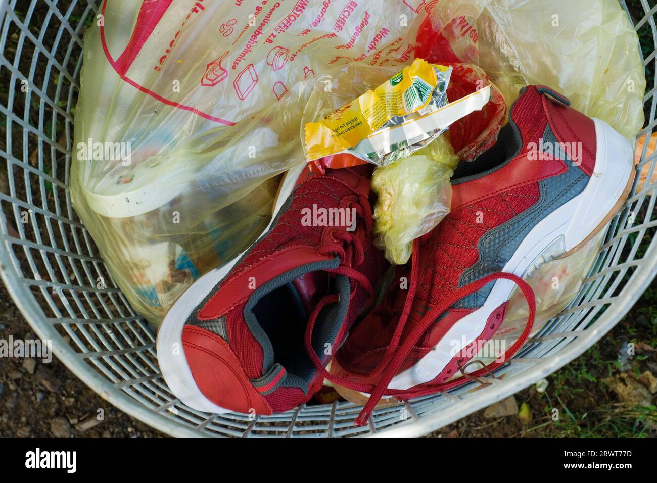 Trainers in a dustbin Stock Photo - Alamy