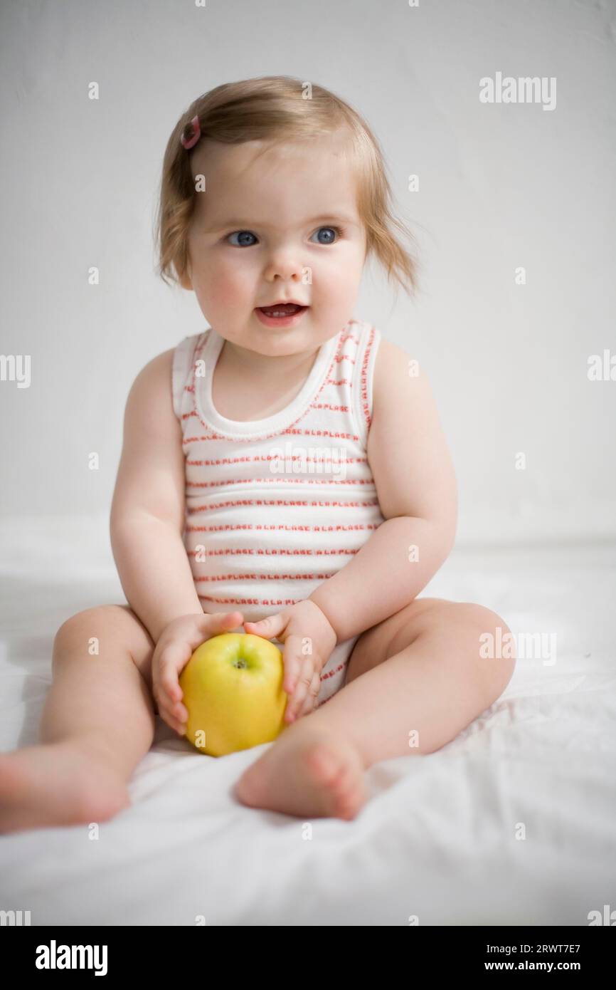 Baby eats her first apple Stock Photo - Alamy