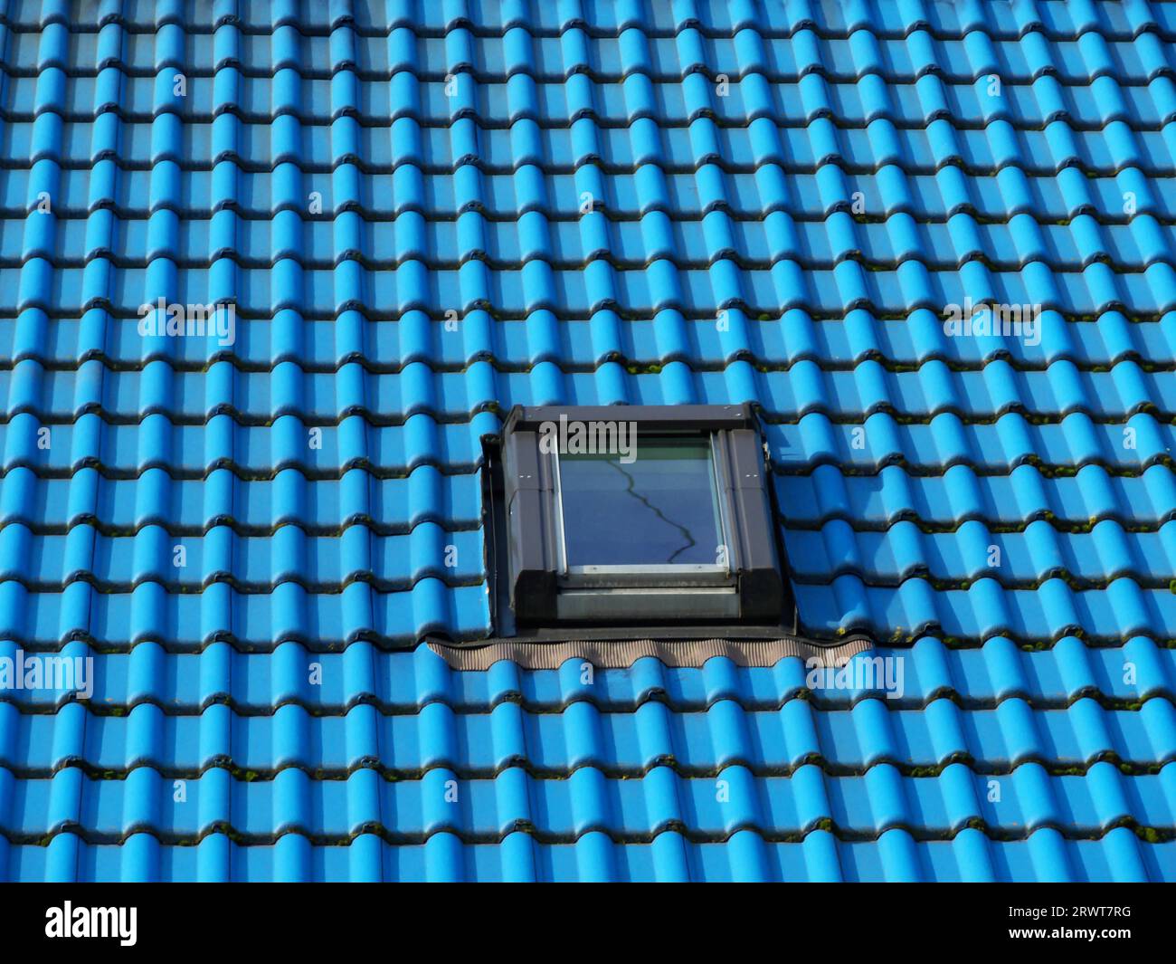 Roof with blue tiles and a roof hatch, format-filling Stock Photo - Alamy