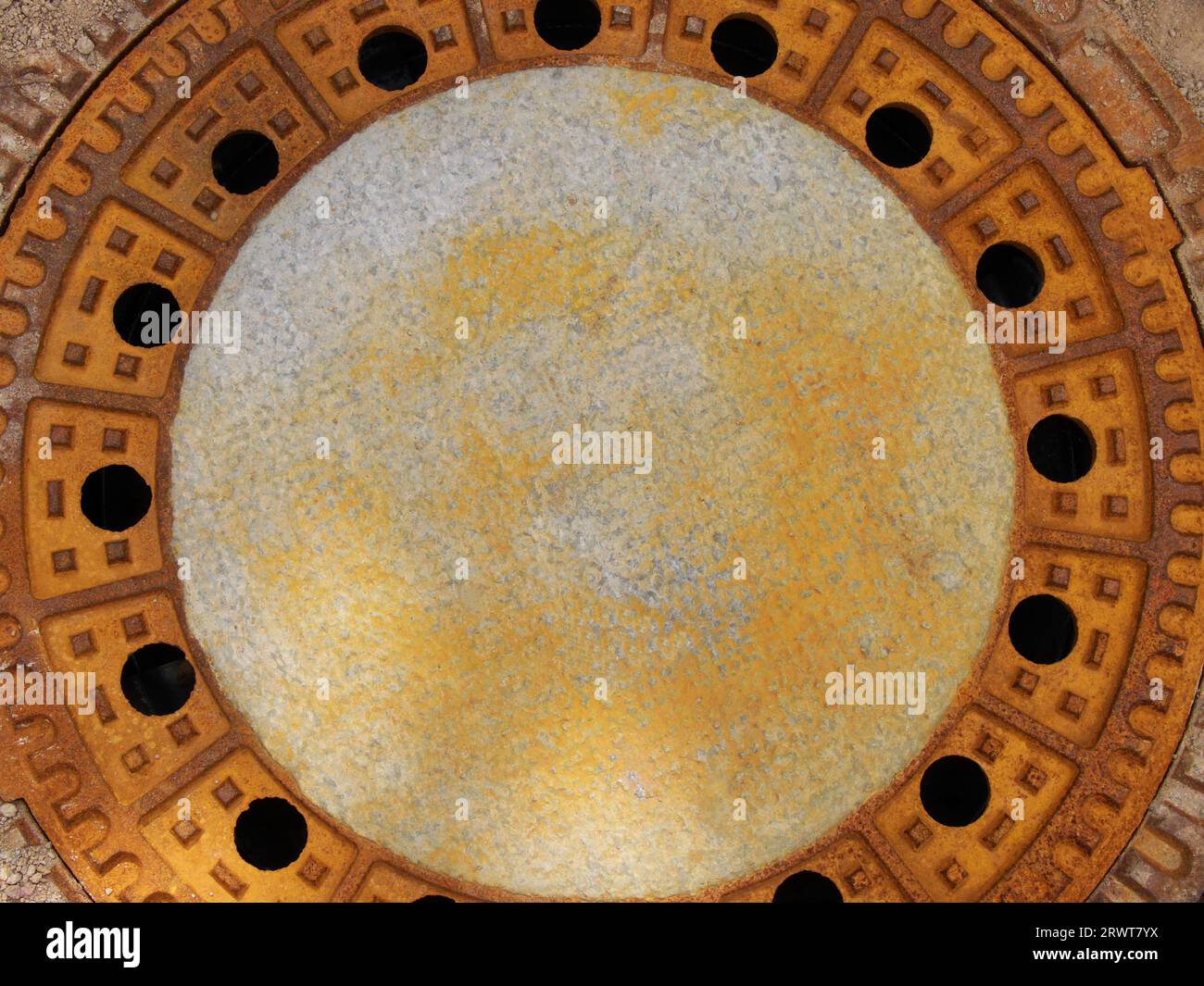 Rusty manhole cover, slightly shaded Stock Photo - Alamy