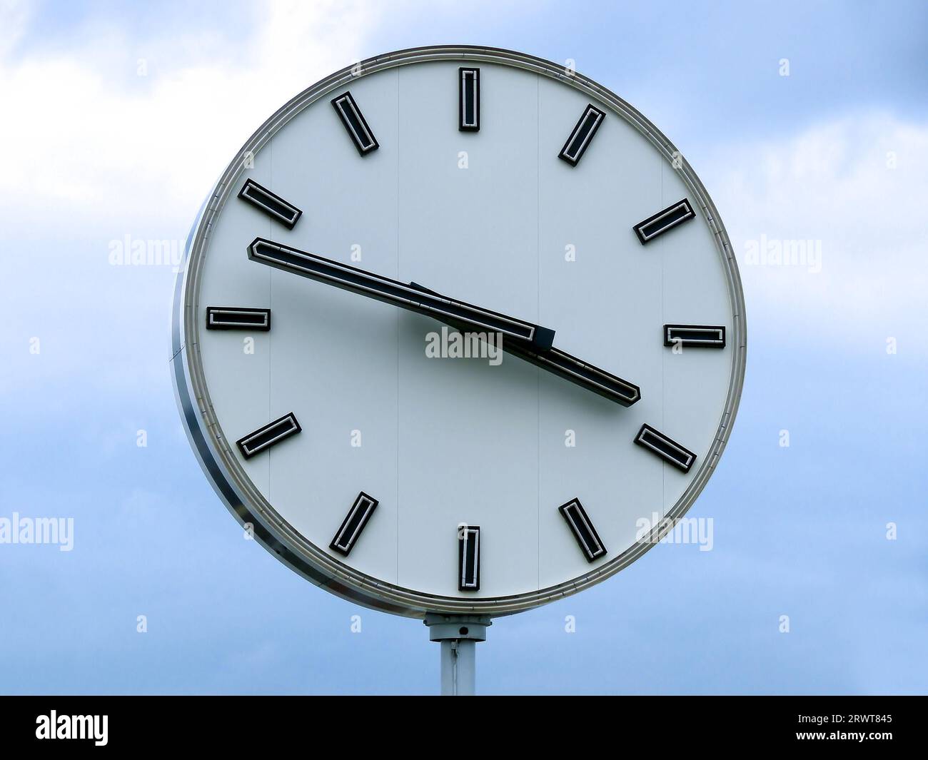 Oversized time indicator with hands moving to four o'clock, background ...