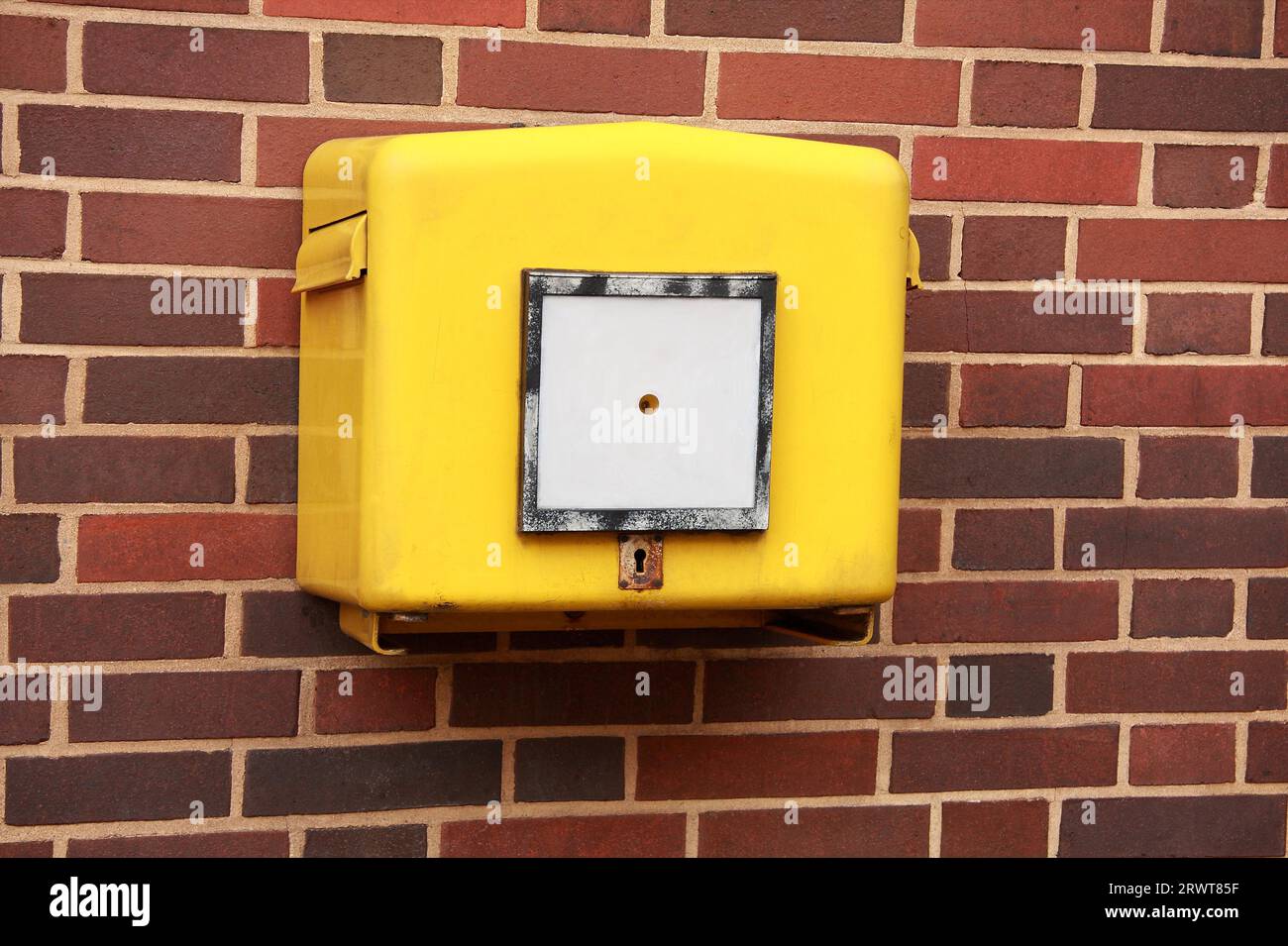 Disused yellow post box in front of brick wall Stock Photo - Alamy