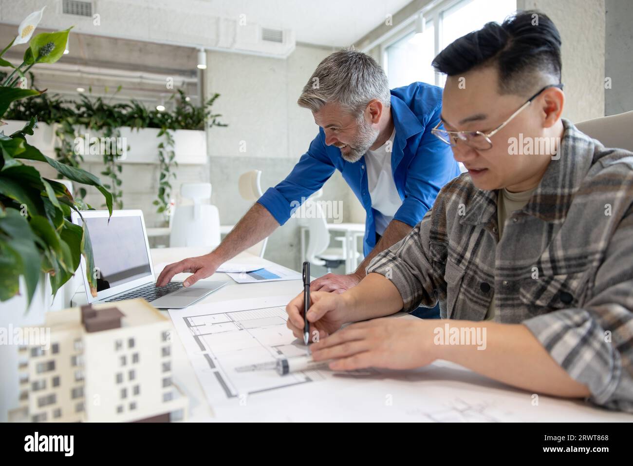 Men working with 3D printer and blueprint for designing mechanical ...