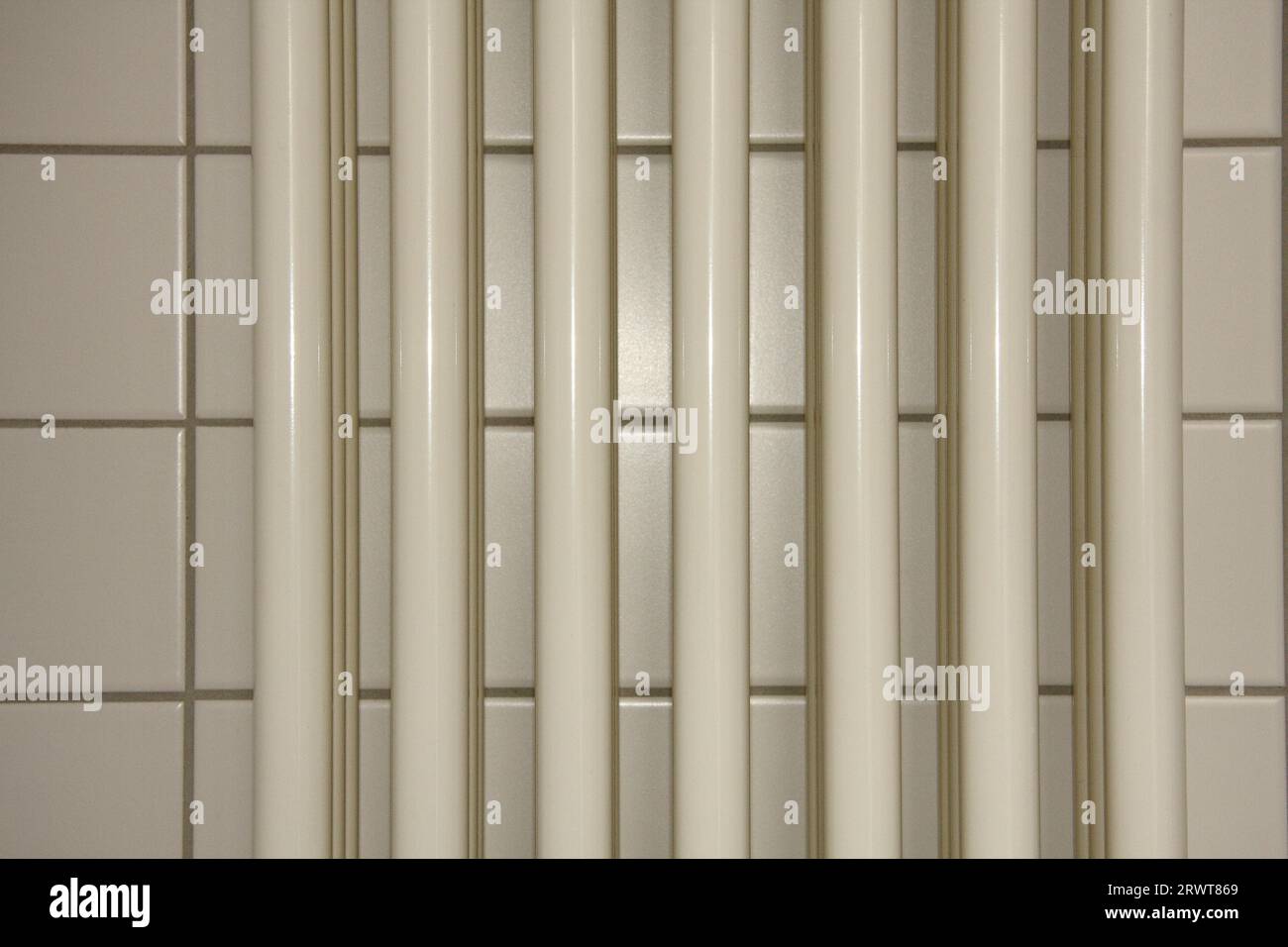 White bathroom radiator in a light beige tiled bathroom, cut-out Stock ...