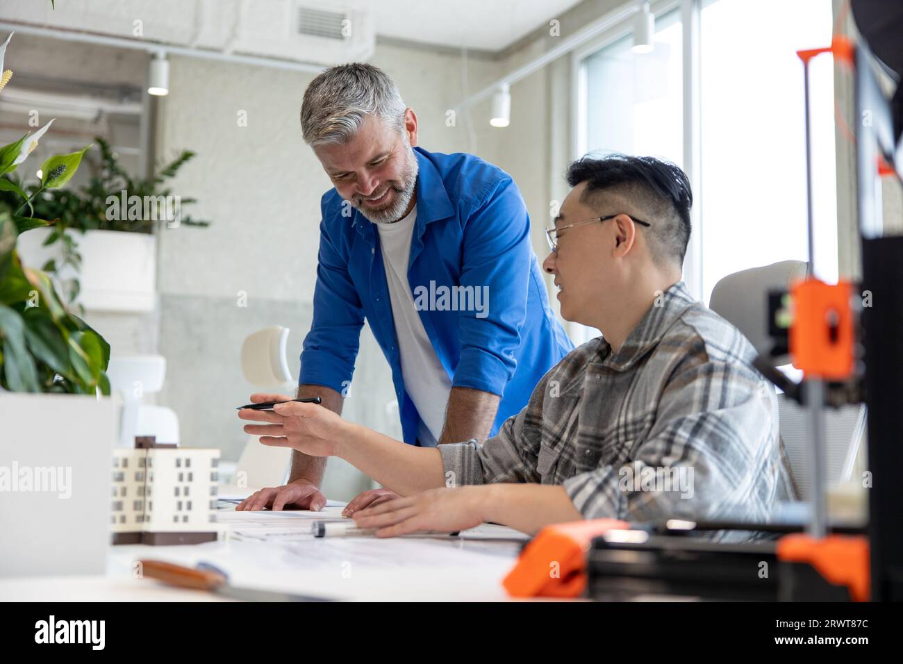 Men working with 3D printer and blueprint for designing mechanical ...