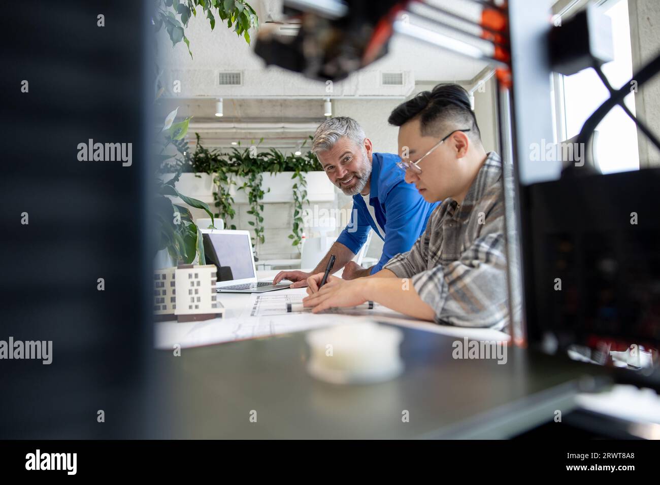 Two men architects using 3D printer in office and projecting house ...