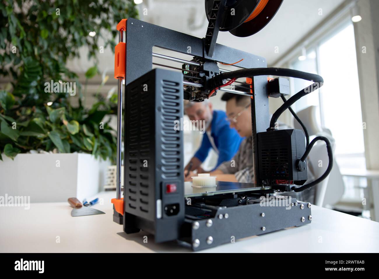 Two men architects using 3D printer in office and projecting house ...