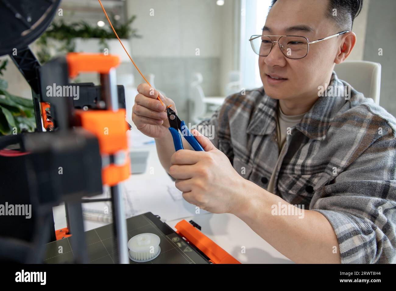 Engineering man designing mechanical parts using 3D printer in office ...