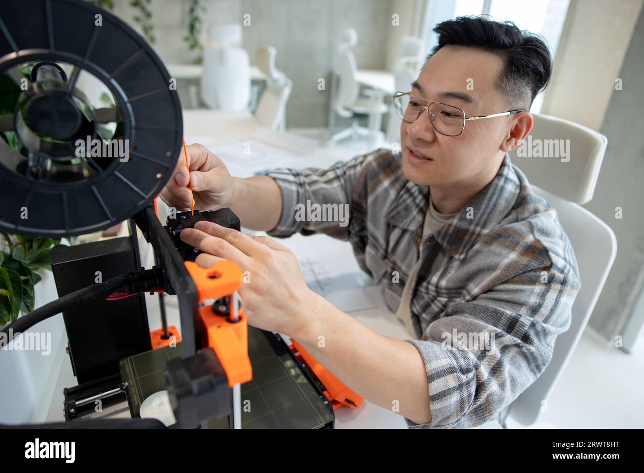 Engineering man designing mechanical parts using 3D printer in office ...