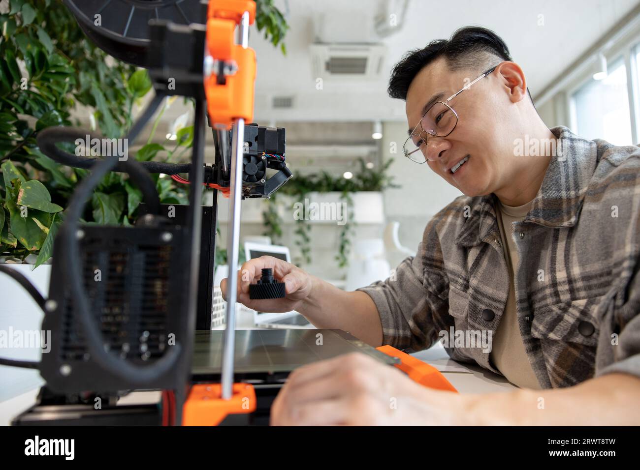 Engineering man designing mechanical parts using 3D printer in office ...