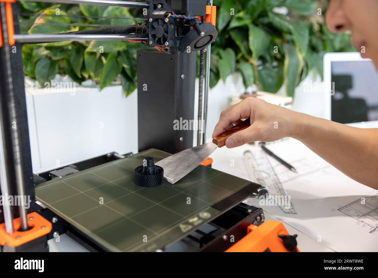 Asian designer engineer using 3D printer in laboratory and studying ...