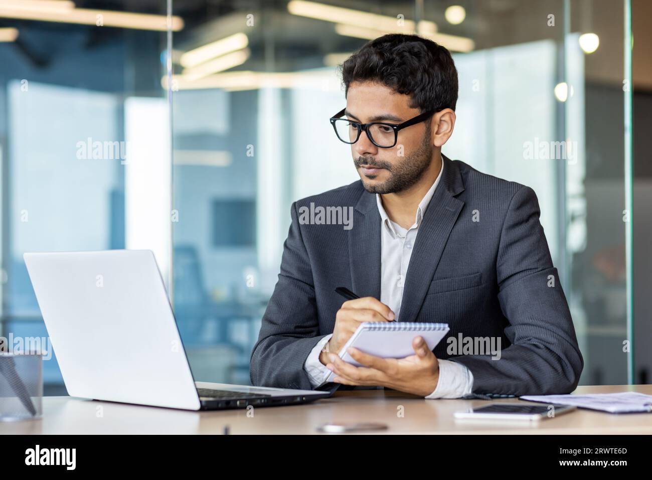 Serious and concentrated thinking businessman watching webinar online ...