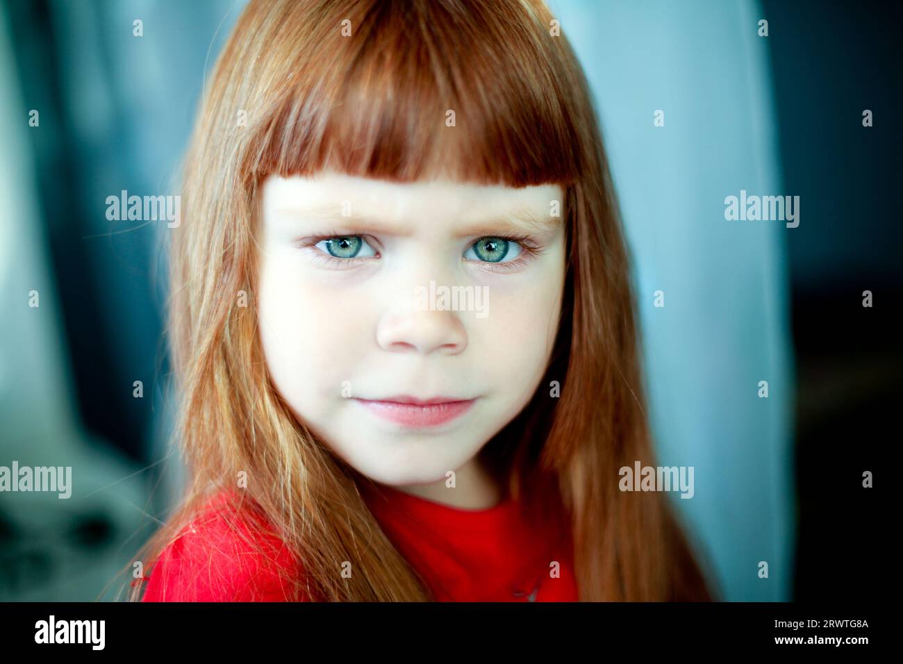 little red-haired girl is angry, mad and looking at the camera. Emotion ...