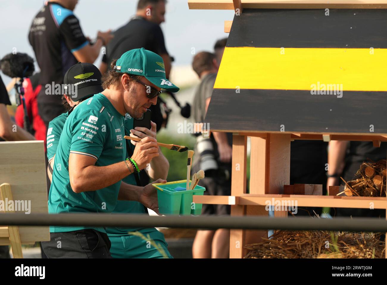 Aston Martin driver Fernando Alonso of Spain paints an insect house ...