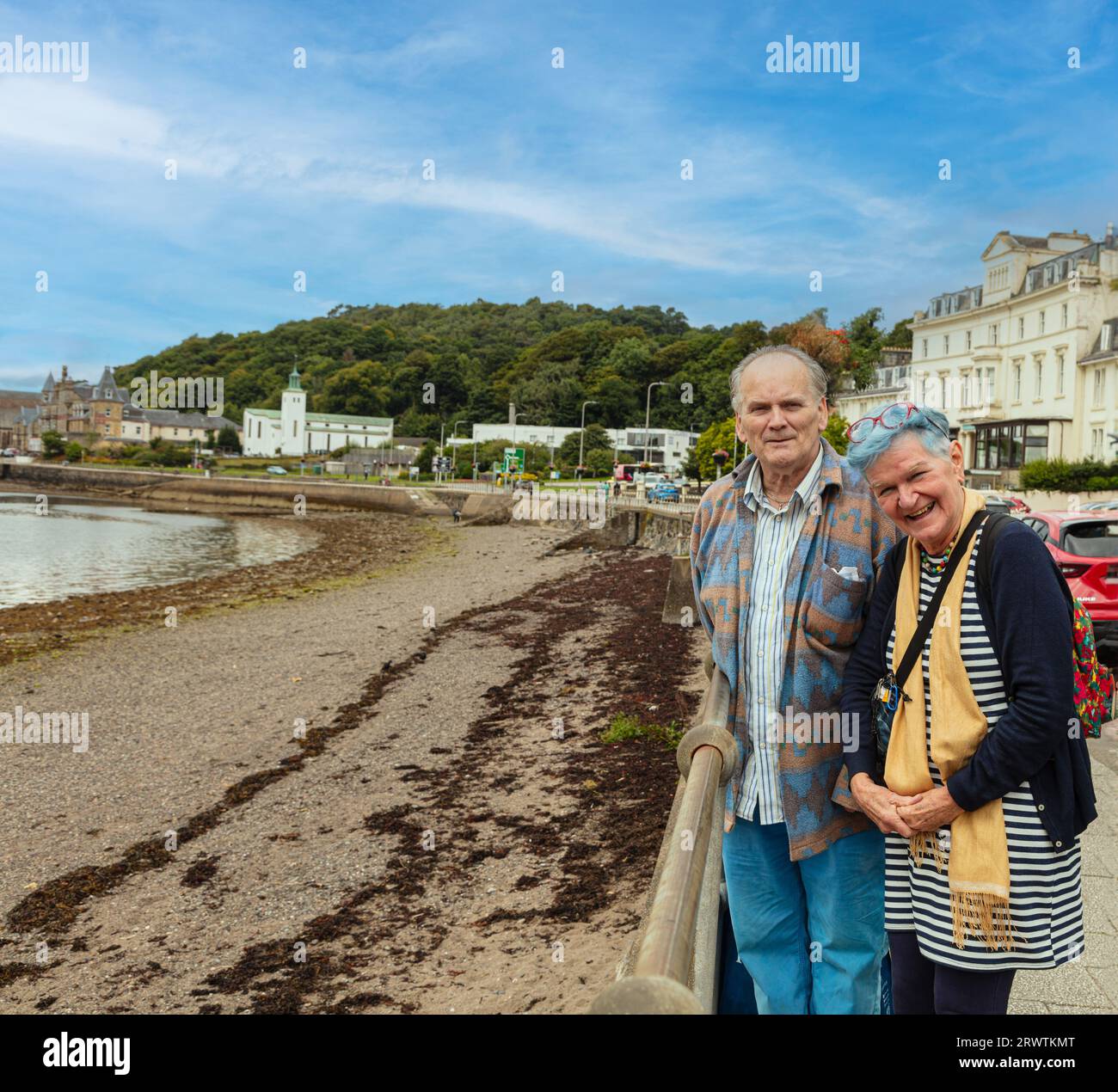 Acitve senior couple, 60 year old, walk along the beach, sightseeing in ...
