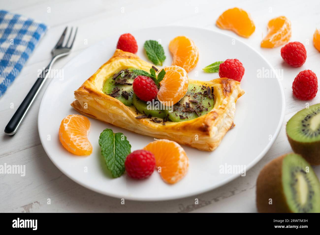 Puff pastry tartlet with pastry cream and kiwi decorated with fresh ...