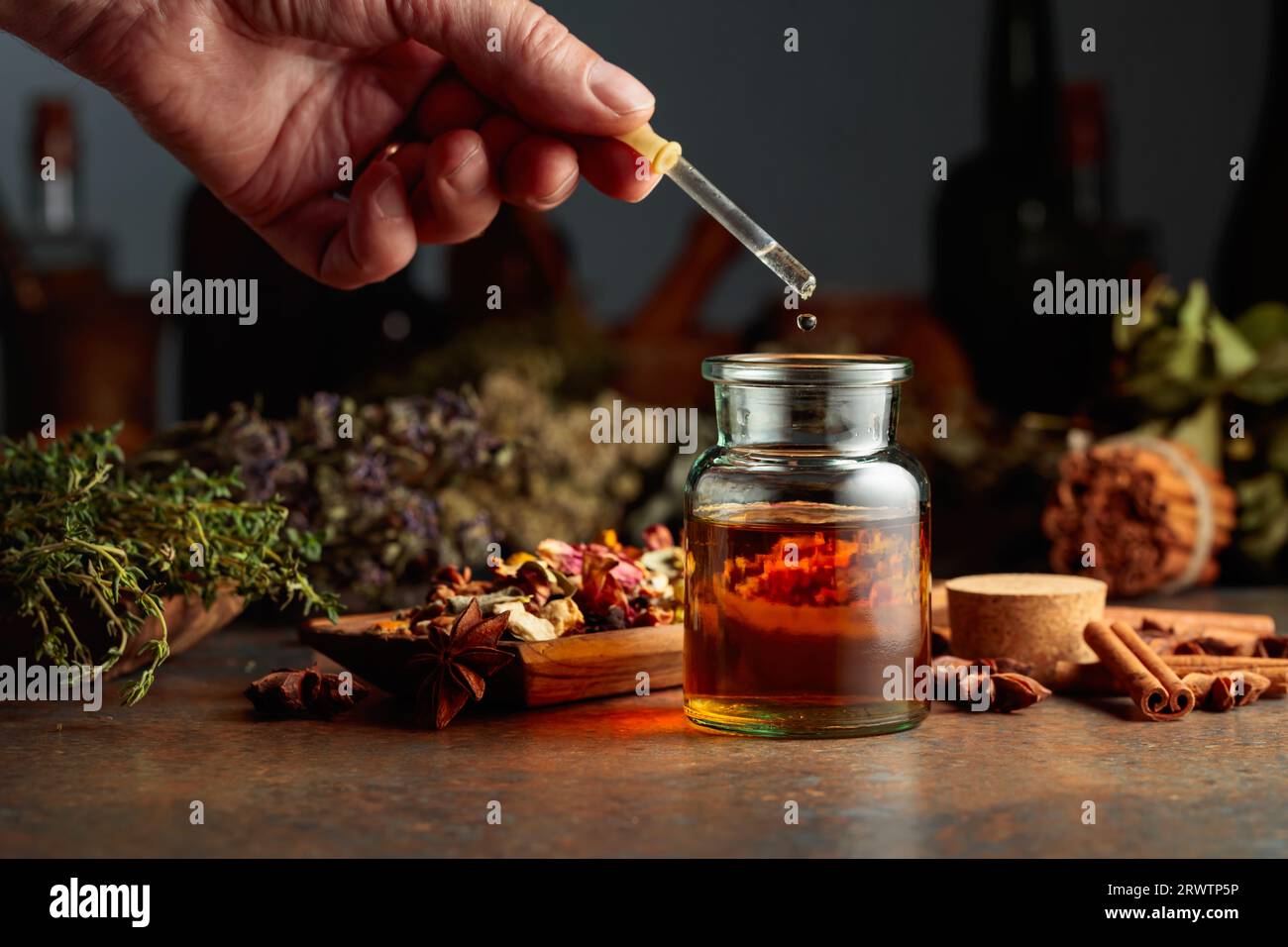 Dropping essential herbal tincture into a small glass bottle. On a ...