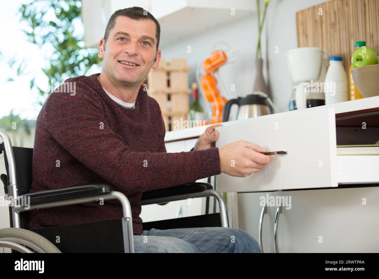 happy disabled man sitting on wheelchair open drawer in kitchen Stock ...