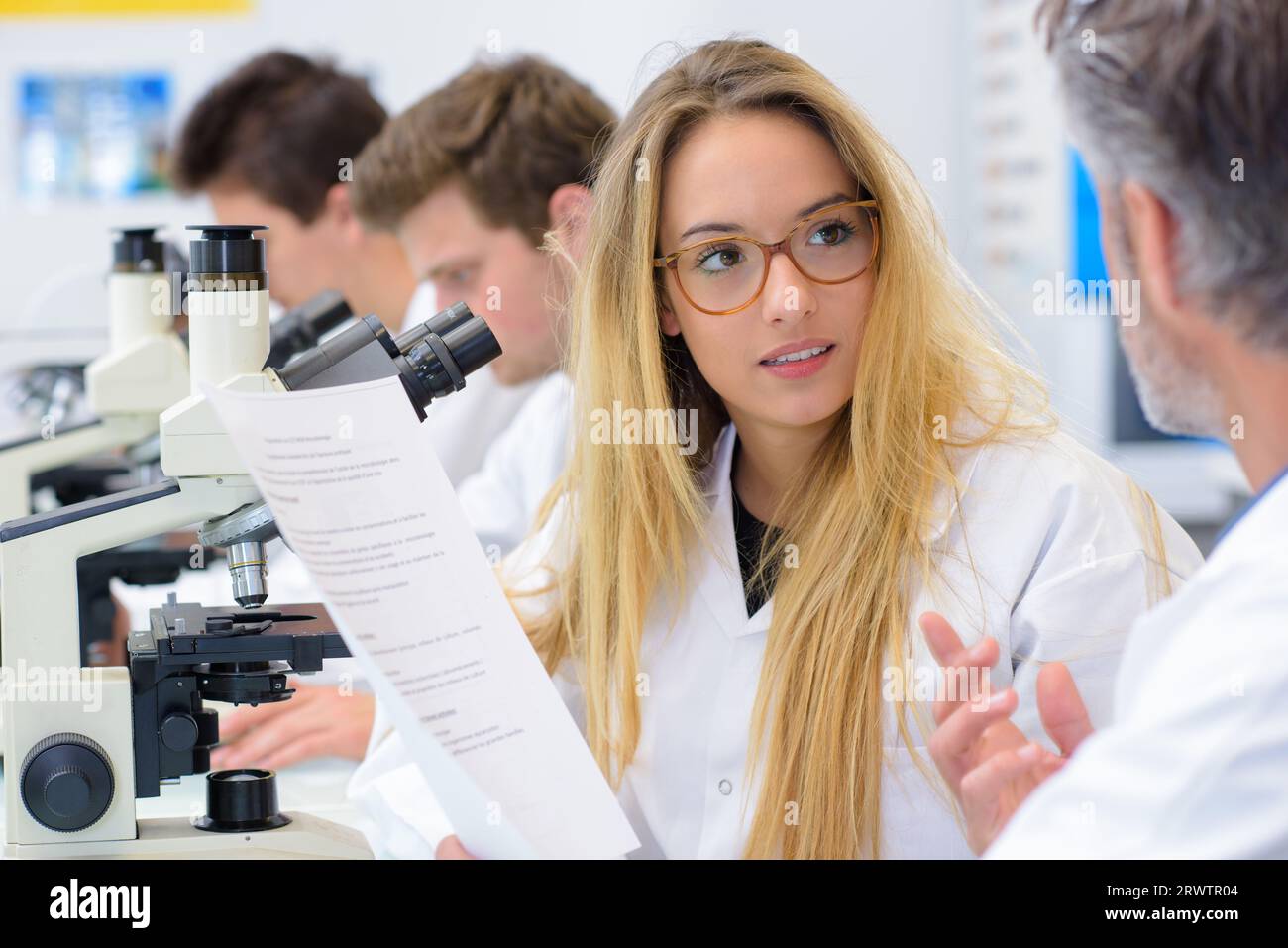 Female science student talking with teacher Stock Photo - Alamy