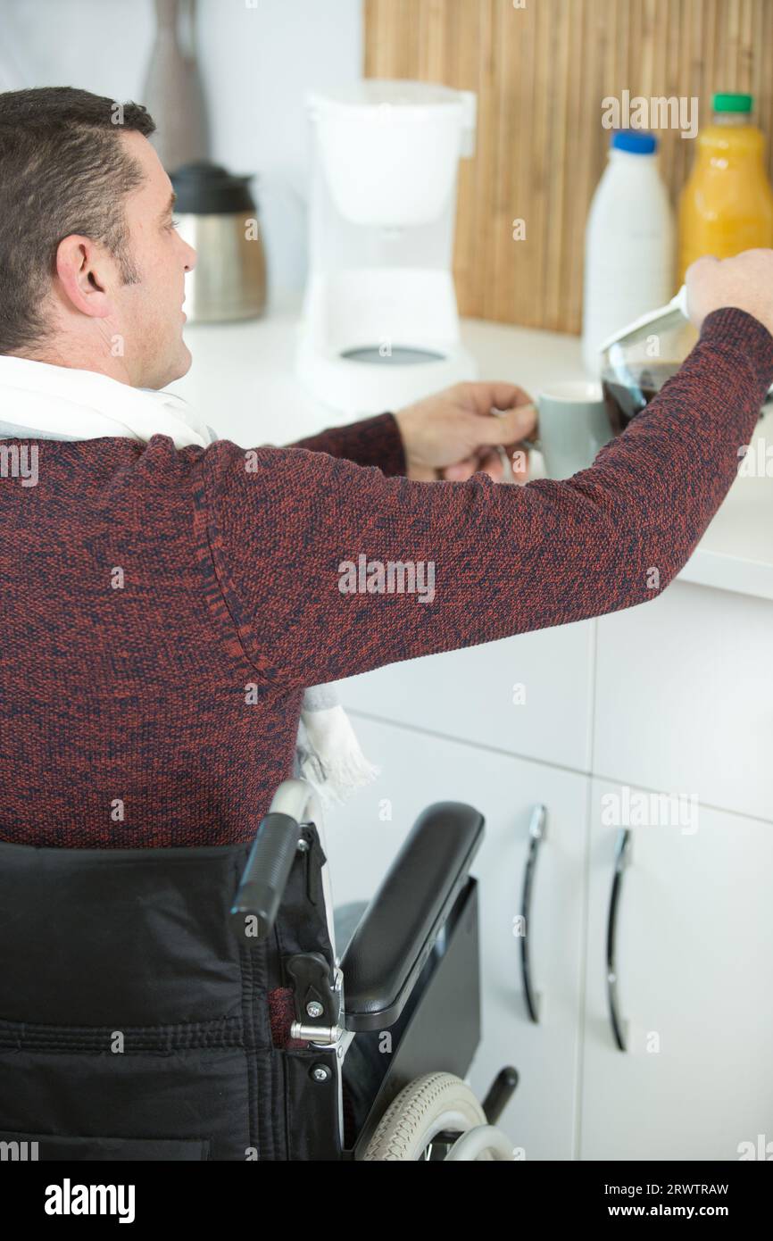 disable man in a wheelchair is making coffee Stock Photo - Alamy