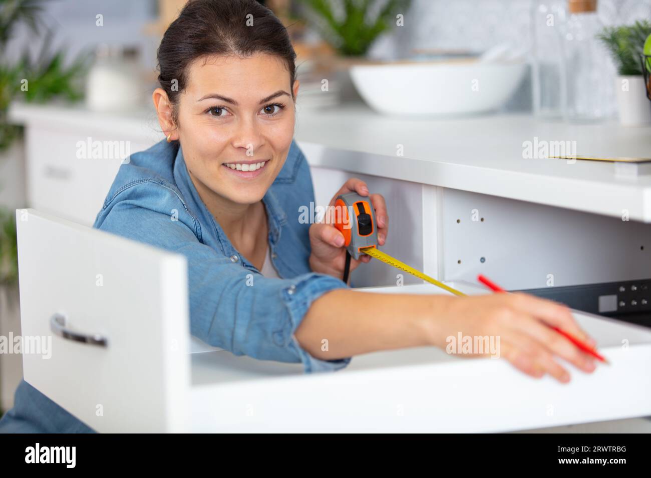 beautiful brunette woman building kitchen Stock Photo - Alamy