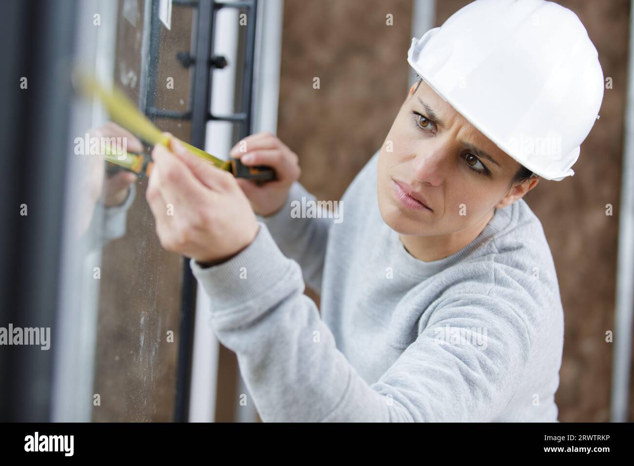 portrait of female builder with extended tapemeasure Stock Photo - Alamy