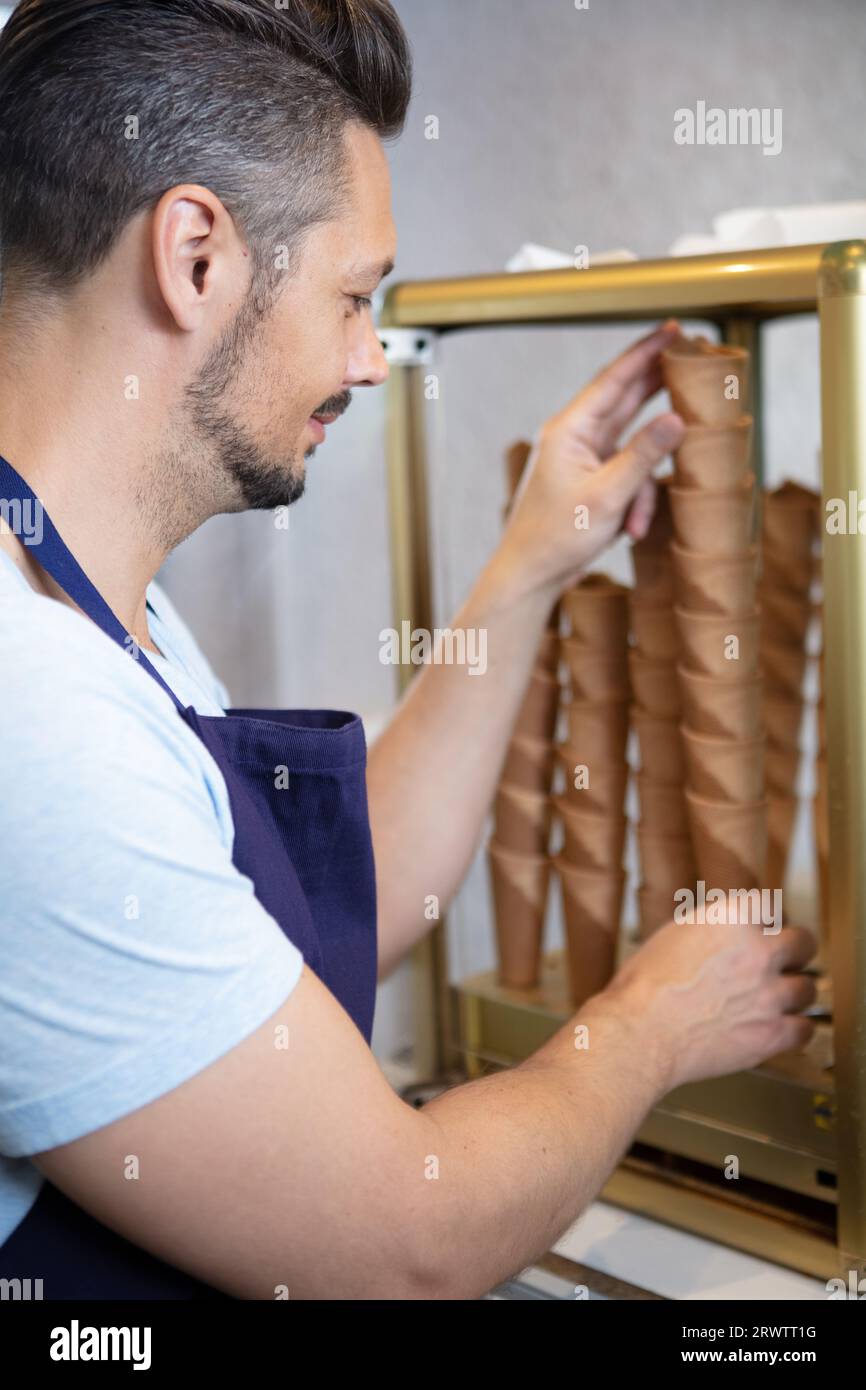 ice cream parlour worker restocking cones Stock Photo - Alamy