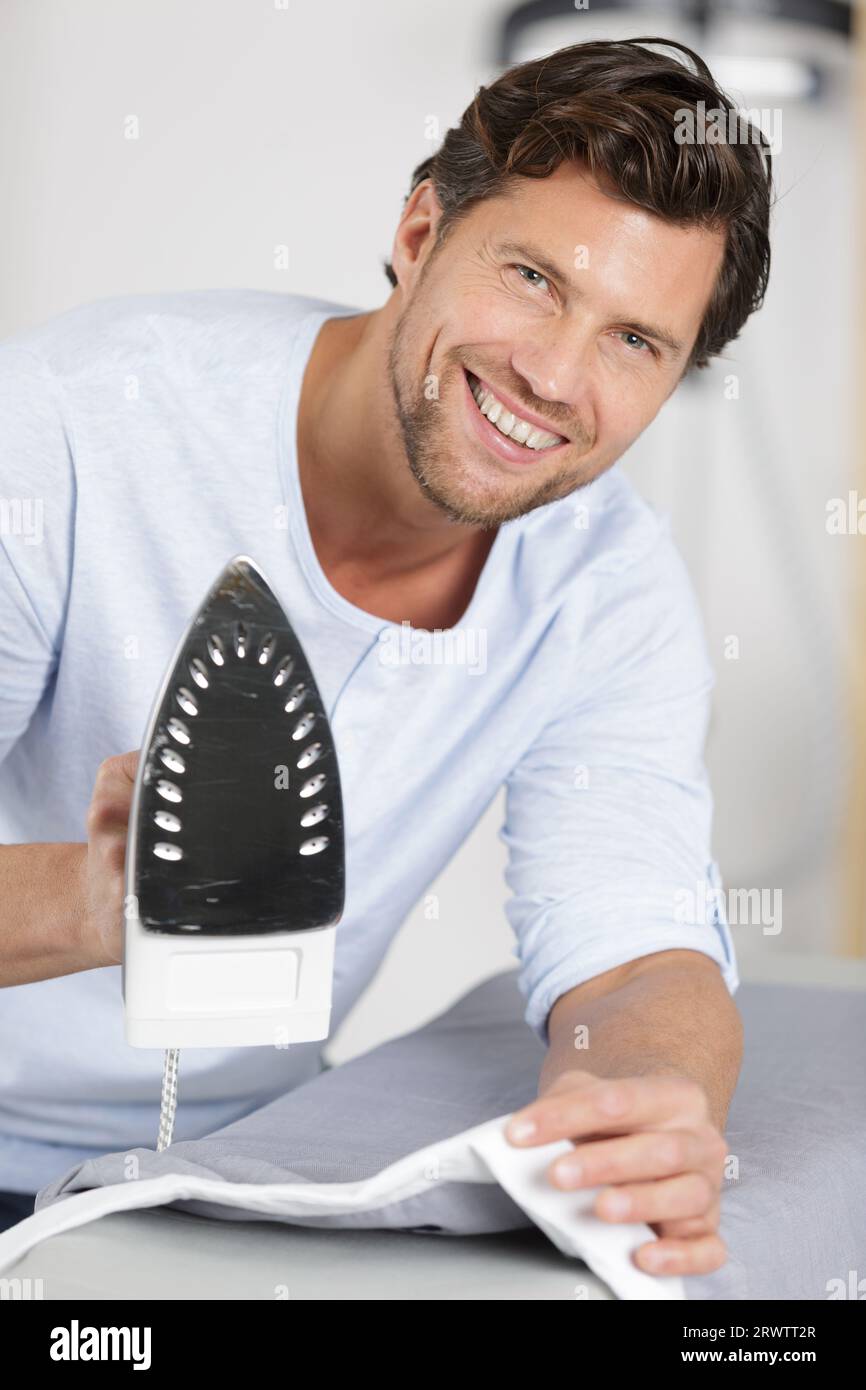 Portrait of a man ironing clothes on an ironing board hi-res stock ...