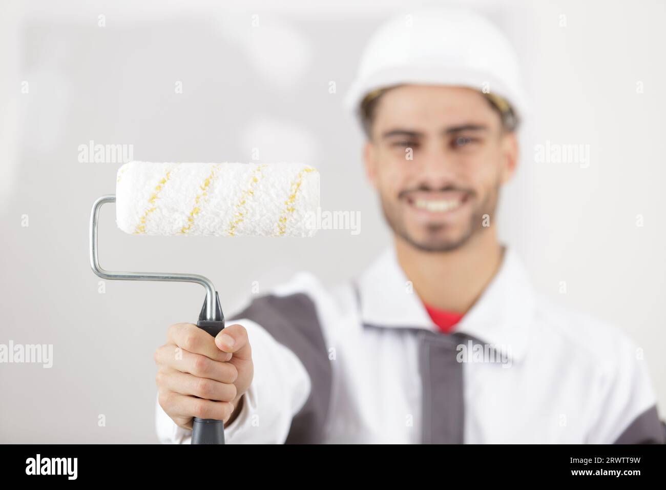 a happy painter holds a painting roll Stock Photo - Alamy