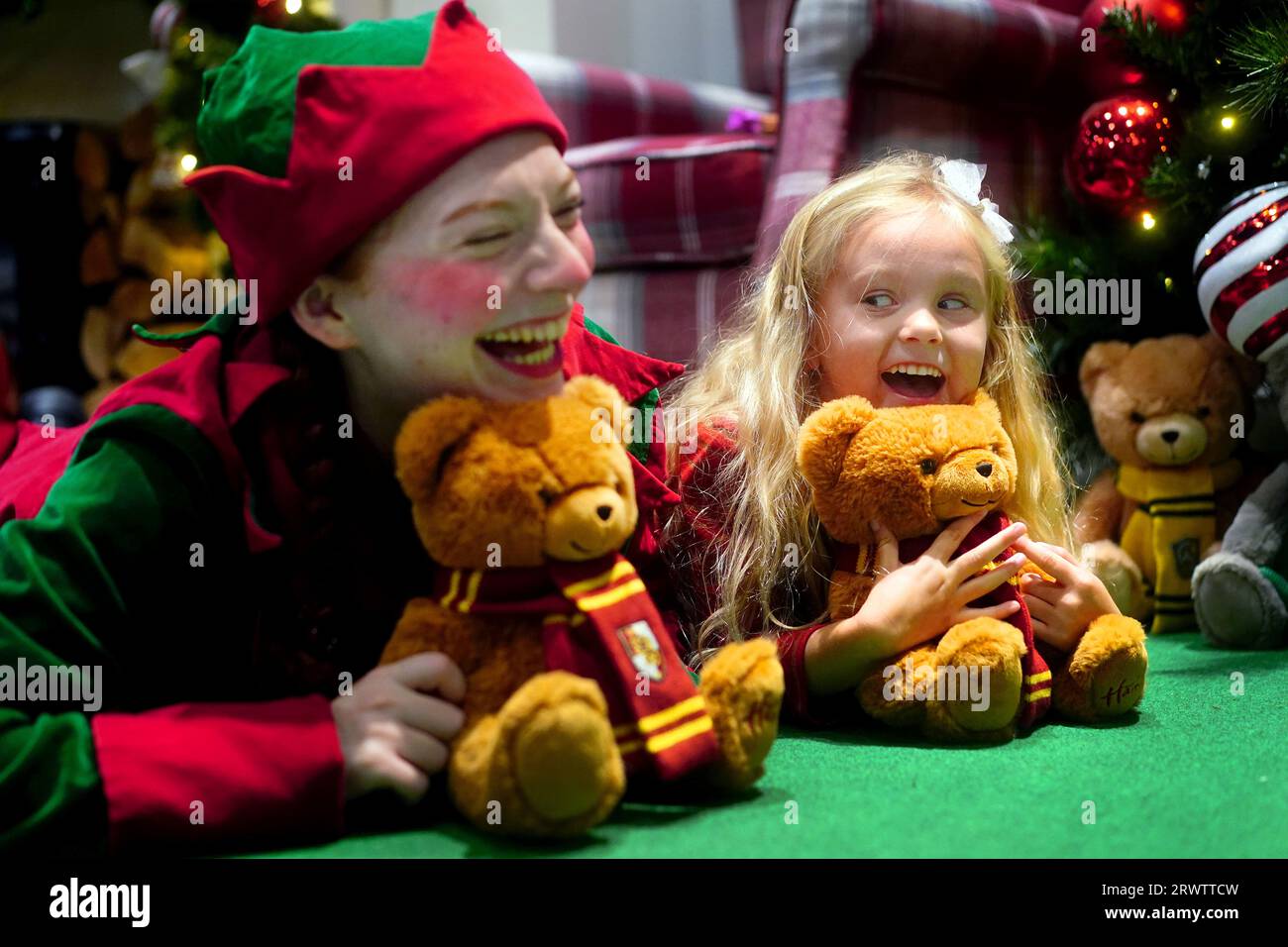 A young girl and an elf play with a Harry Potter bear at the Hamleys ...