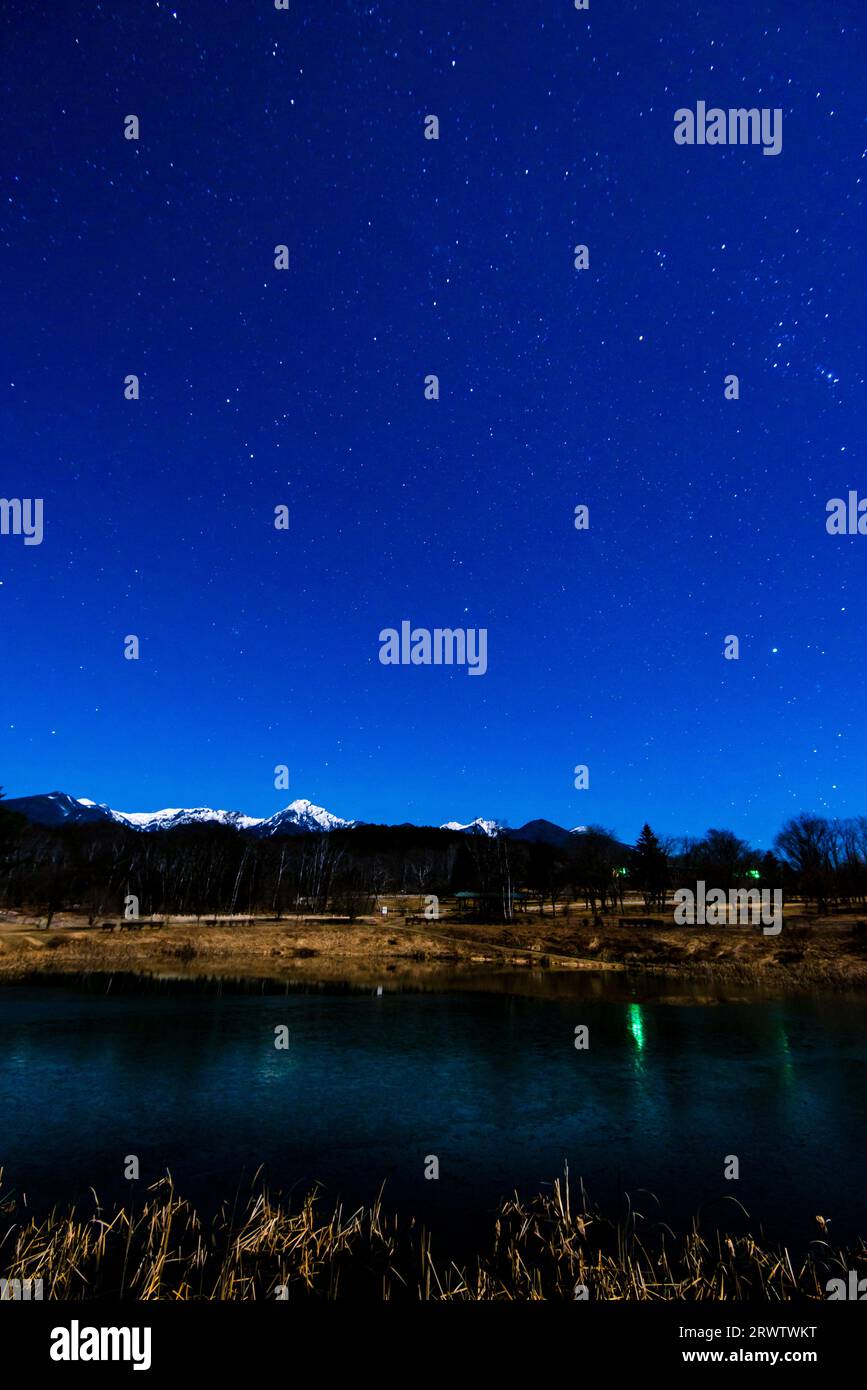 The Yatsugatake mountain range and starry sky from Lake Maruyachi in ...