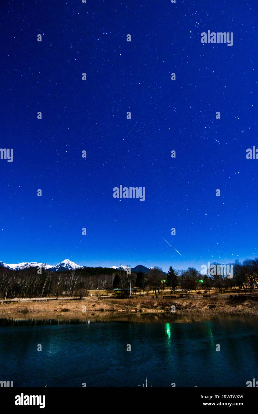 The Yatsugatake mountain range and starry sky from Lake Maruyachi in ...