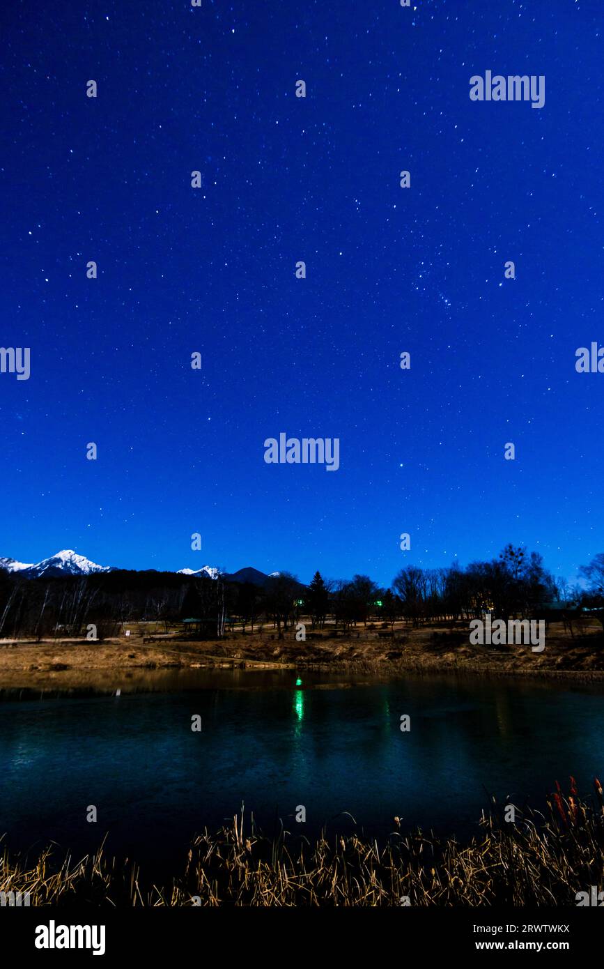 The Yatsugatake mountain range and starry sky from Lake Maruyachi in ...