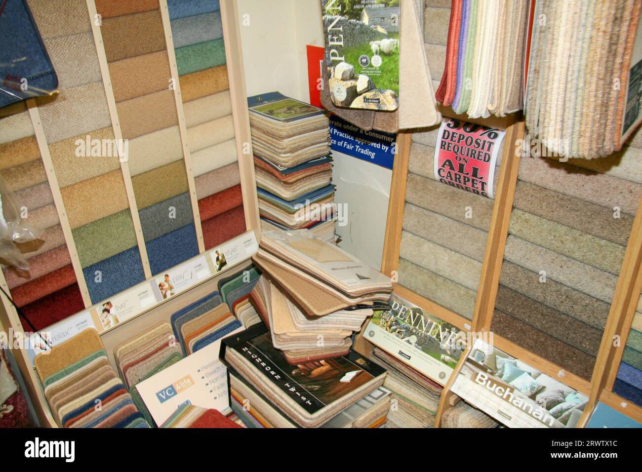 A small shop corner devoted to a display of carpet samples in dull ...
