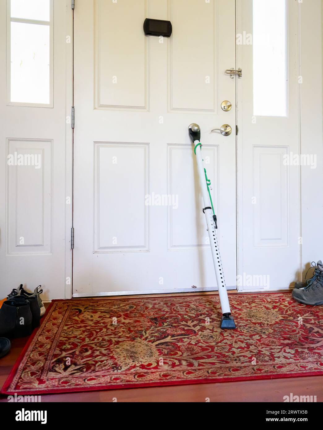 Door security bar against a white front door. View from inside the home ...