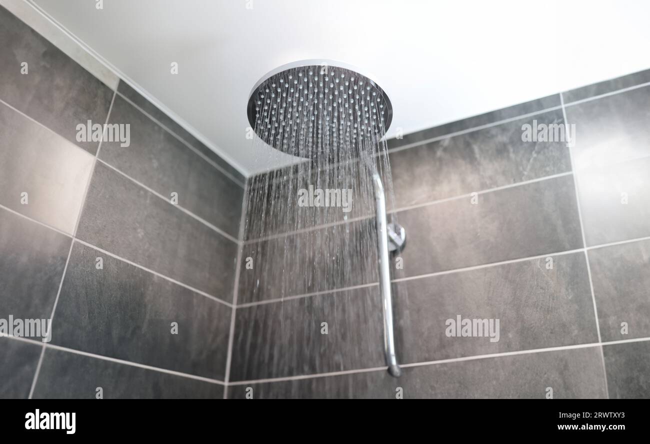 In bathroom, water flows from shower tap Stock Photo - Alamy