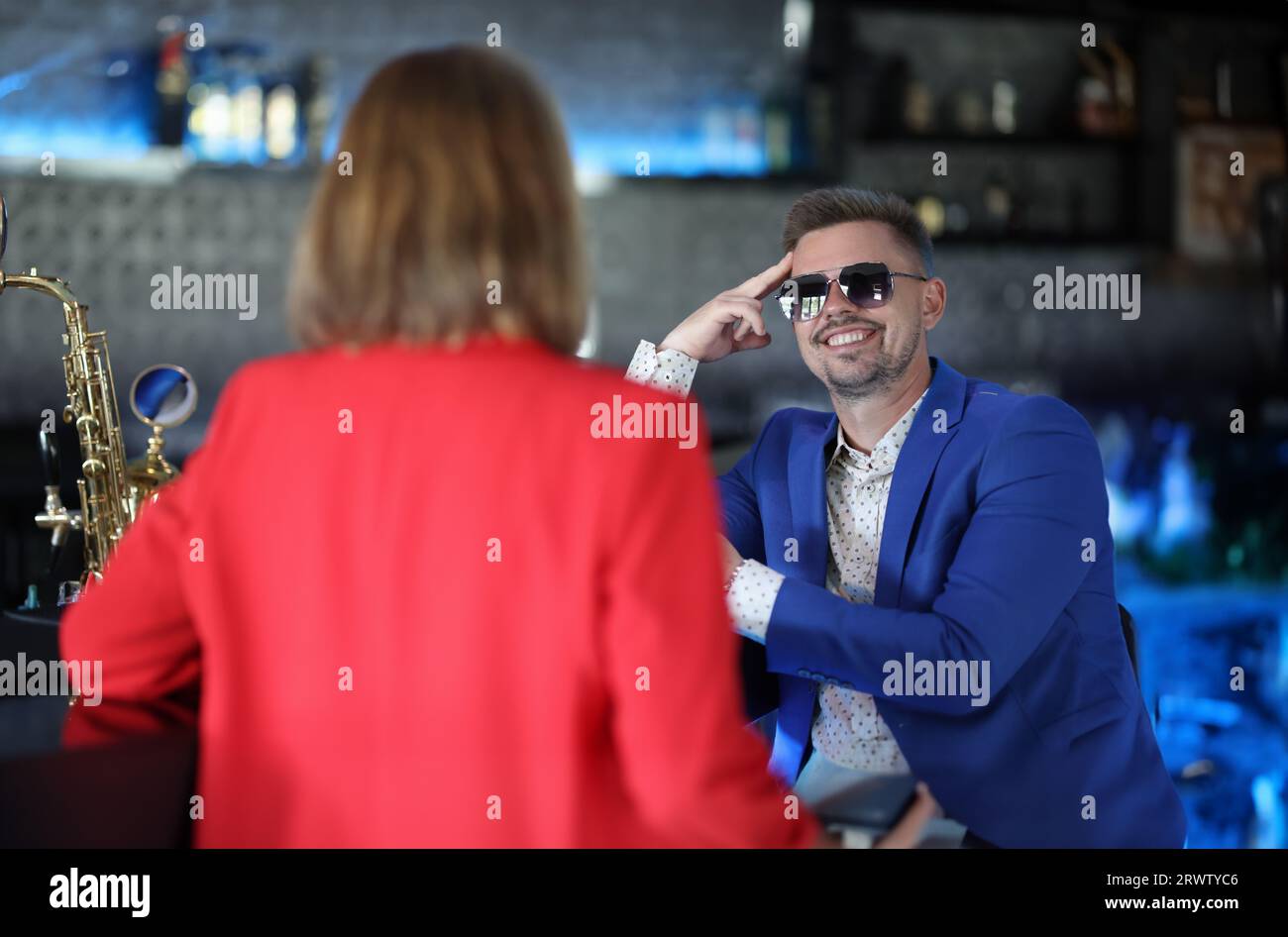 Smiling confident man in sunglasses meets woman near bar counter Stock ...