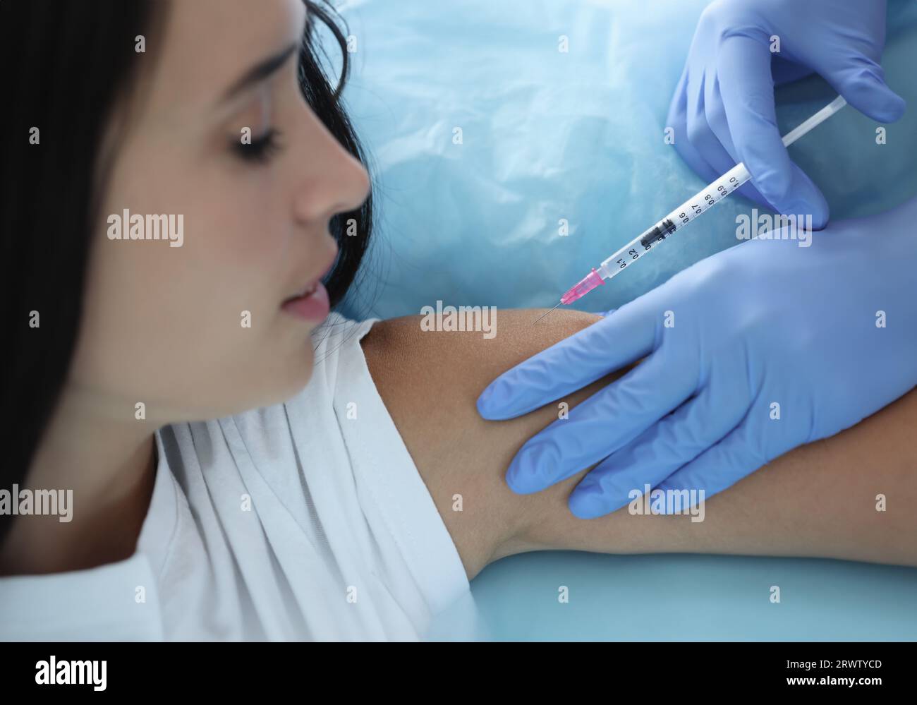 Doctor gives woman an injection in shoulder Stock Photo - Alamy